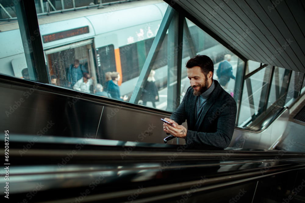 Professional young man in train station using smartphone Stock Photo ...