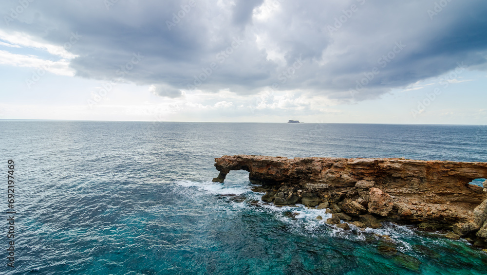 Typical rocky Malta coastline. Arch Ras il-Hamrija (Ghar Hanex) and ...