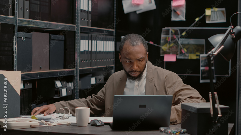 Police officer putting crime case photo on wall board, analyzing clues ...