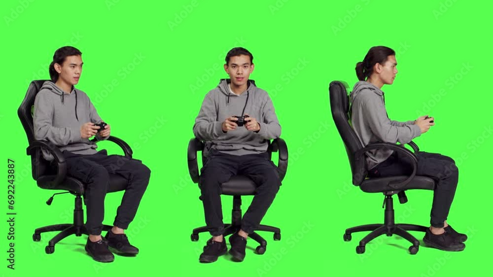 Young gamer playing videogames over full body greenscreen template, using joystick and enjoying ...