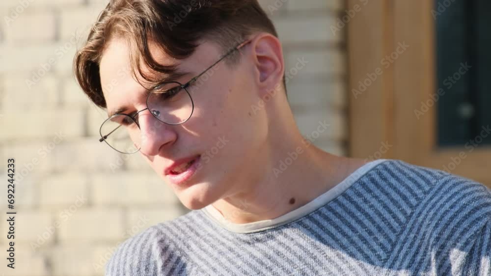 Downcast boy student with glasses sits on flight of stairs experiencing ...