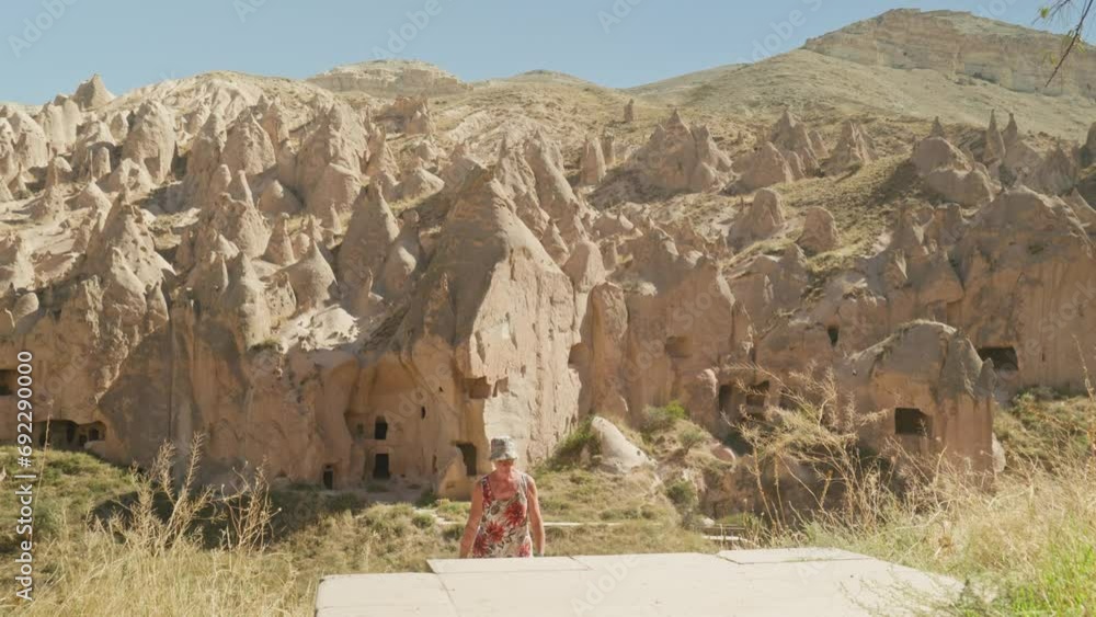 Female tourist climbs steep trail steps explore scenic Zelve landscape ...