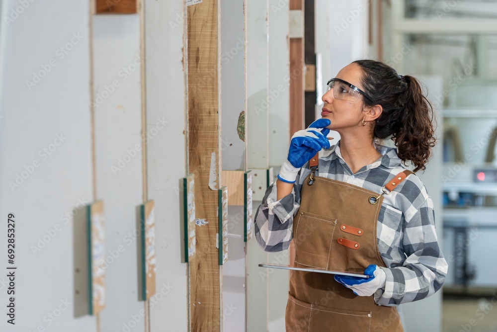 Carpenter woman one smile young aged standing aim working on wood plank ...
