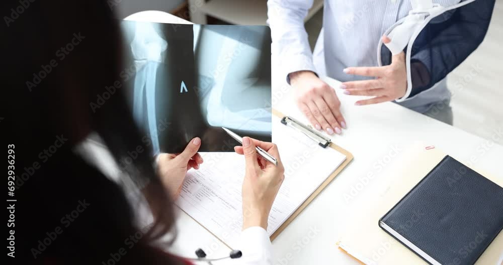 Trauma doctor examines X-ray of patient with severe pain in arm. Help ...