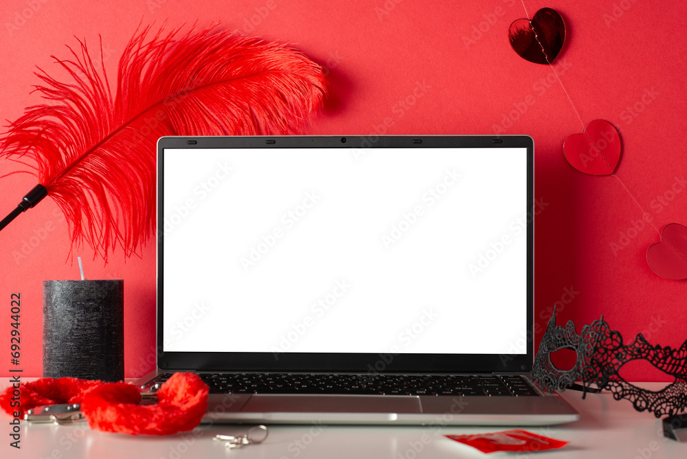 Online intimacy captured in side view scene with a laptop, candle, mask ...