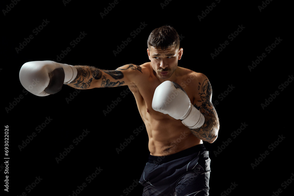 Concentrated serious young man, shirtless boxing athlete with strong ...