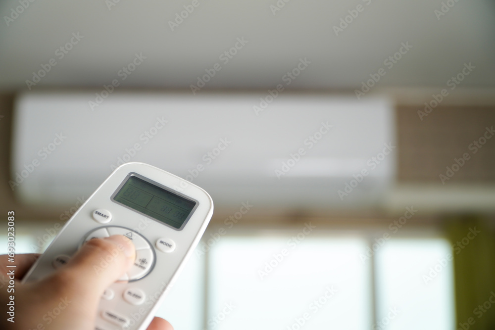 People hold a remote control with air conditioner.Turn on the air ...