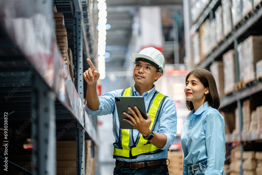 Warehouse staff working together using digital tablets to check the ...