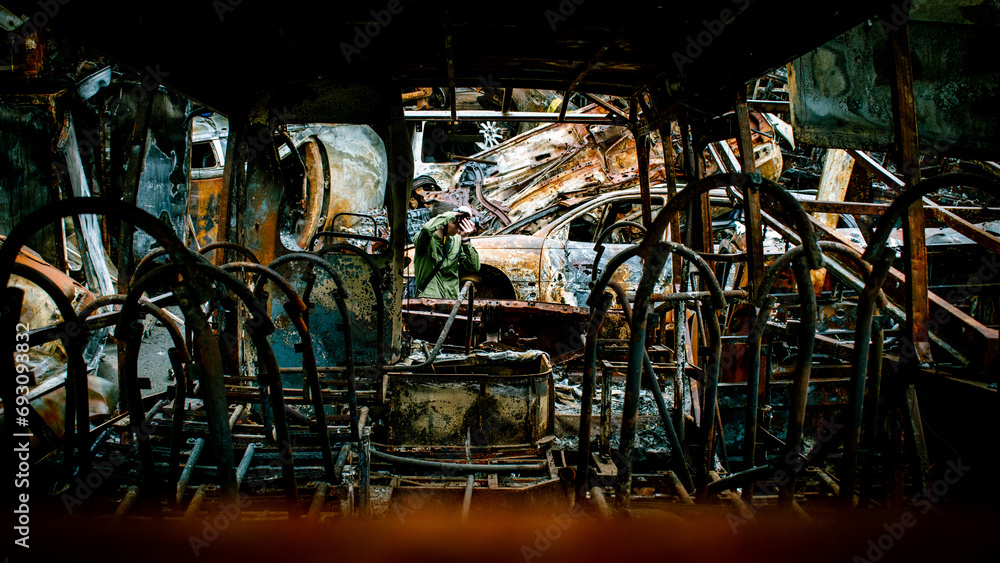 A boy takes pictures of shot cars in the Irpin dump. Landfill of ...
