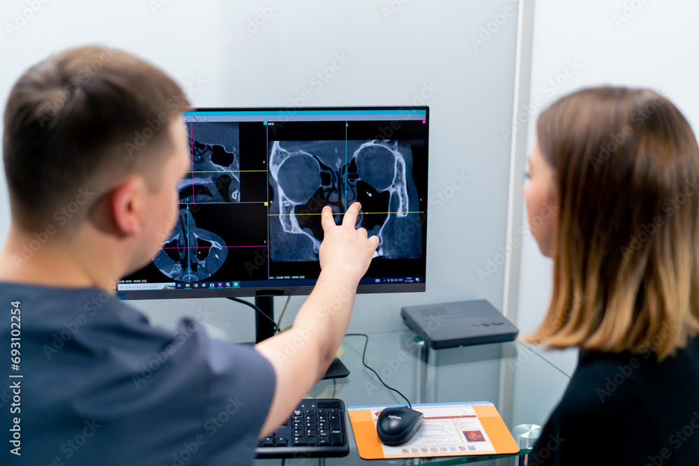 the radiologist doctor looks at the screen on which the 3D image of the ...