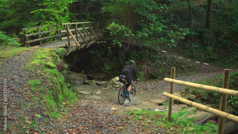 Video „Male cyclist crossing river in mountains on gravel bicycle ...