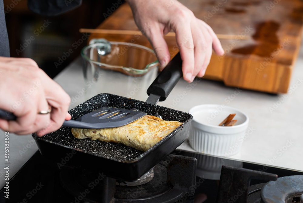 Chef man hands cooking Tamagoyaki or Tamago traditional Japanese Rolled ...