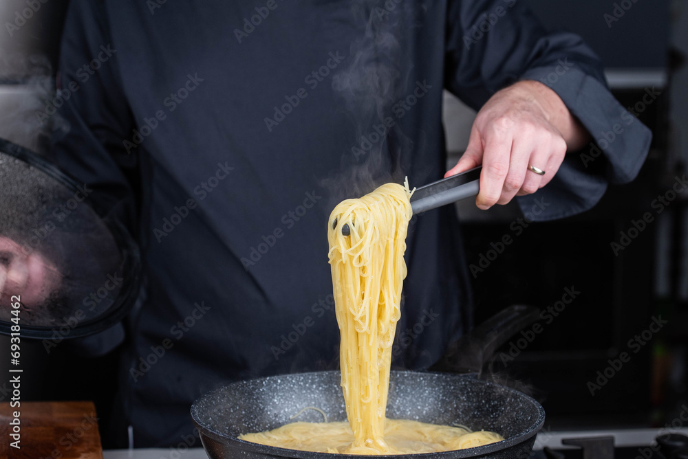 Professional chef cooks making Italian Capellini spaghetti pasta at ...