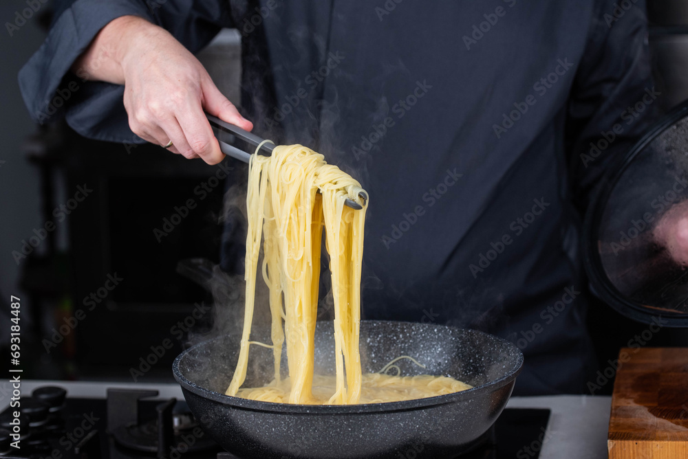 Professional chef cooks making Italian Capellini spaghetti pasta at ...
