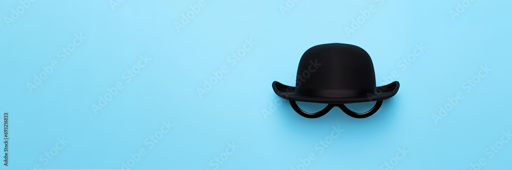 Classic black bowler hat on blue background, simulates face of vintage ...