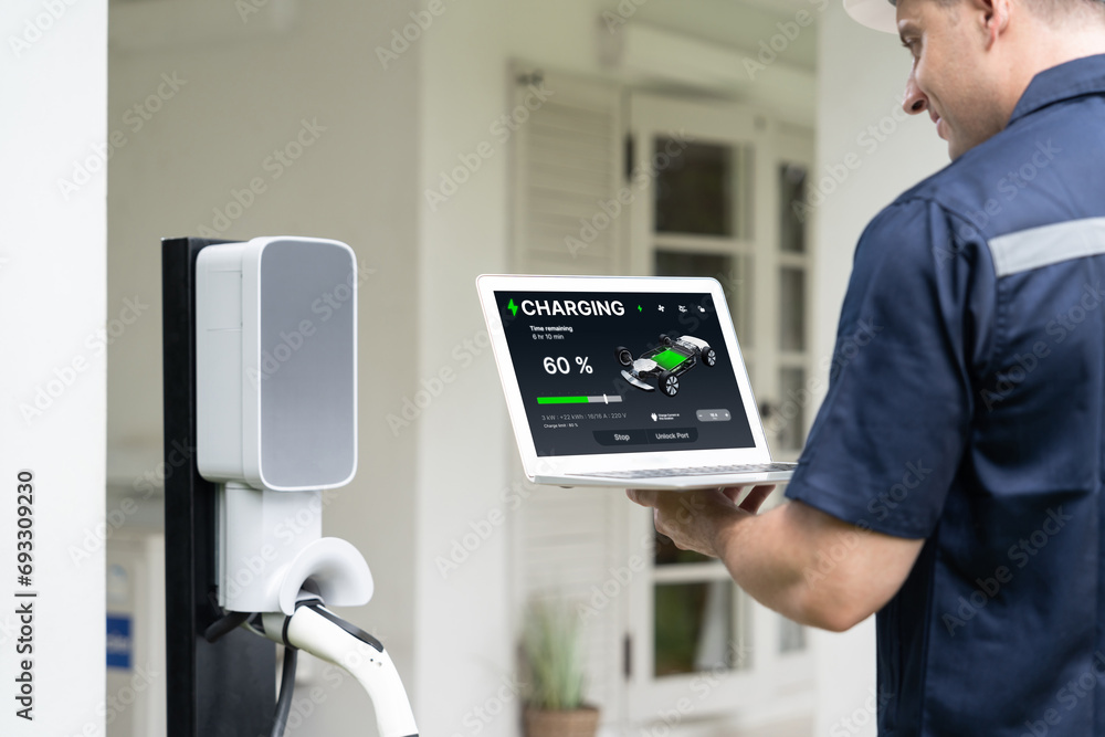 Qualified technician working on home EV charging station installation ...