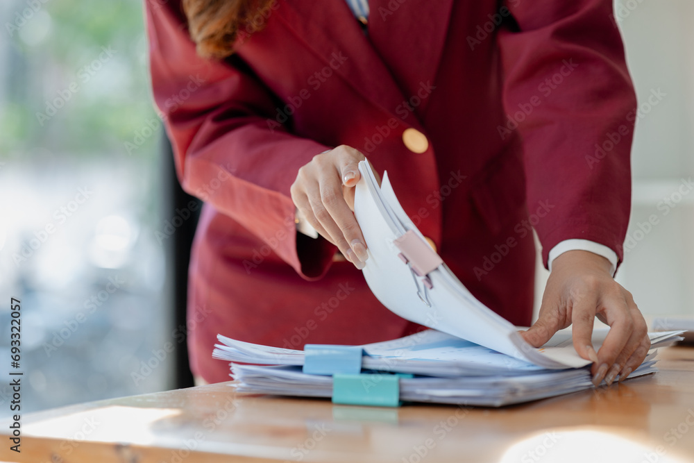 Businesswoman hands working in stacks of paper files for searching ...