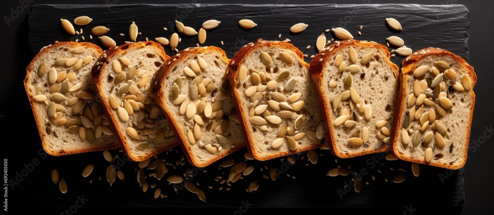 Top-down photo of sunflower seed bread slices on dark table ...