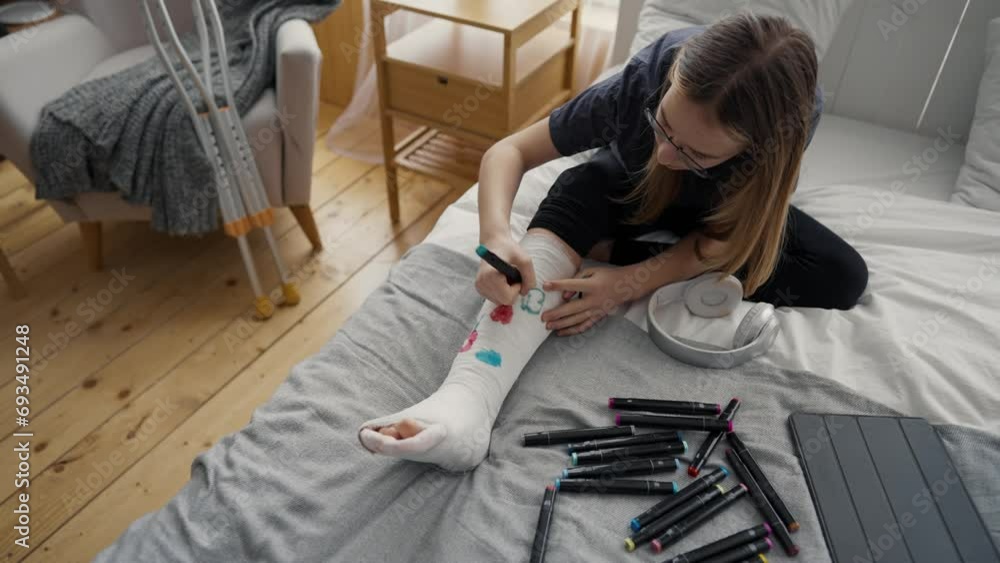 Teenage girl after injury with broken leg in orthopedic cast painting ...