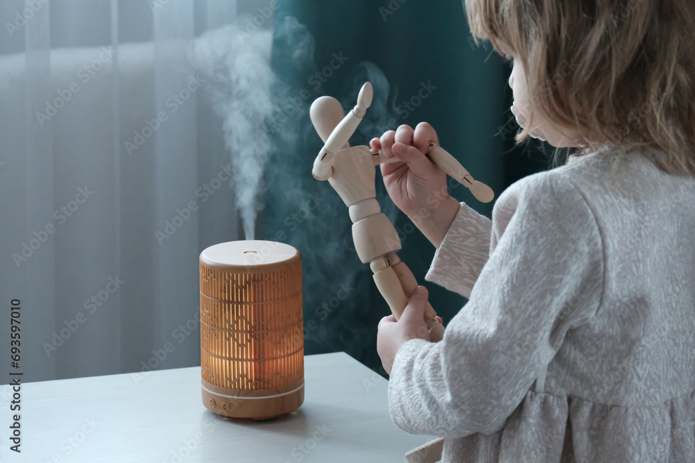 Wooden diffuser, yellow light, electric aromatic. A little blonde girl ...