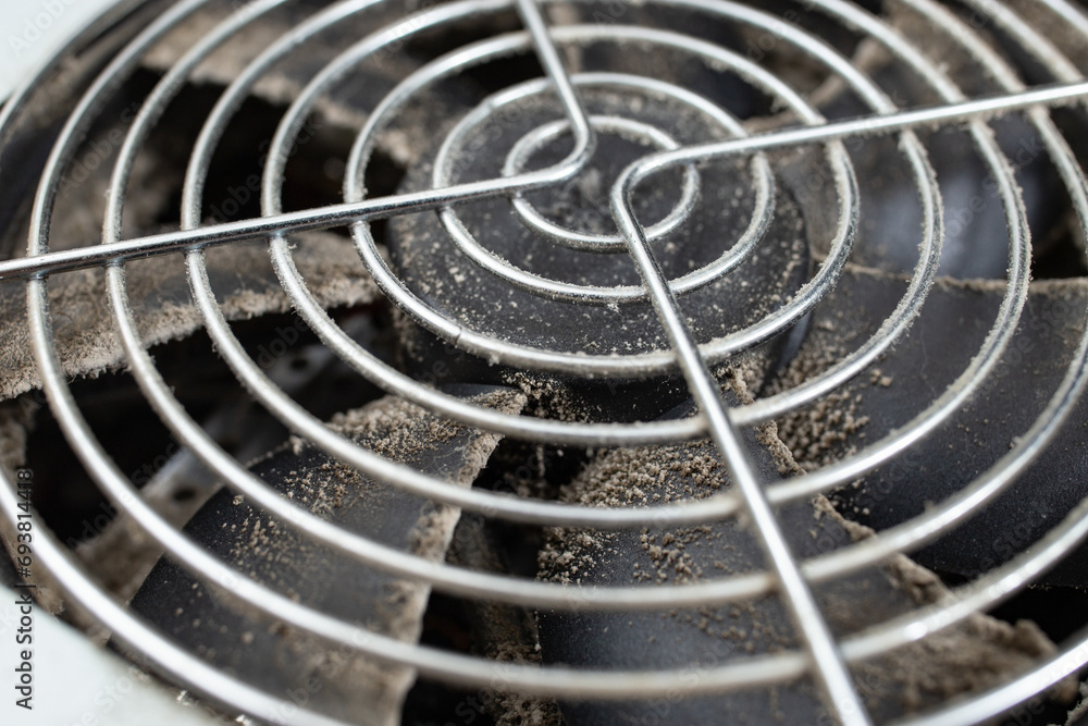 Very dirty pc fan with lots of dust and steel grate, soft focus close ...