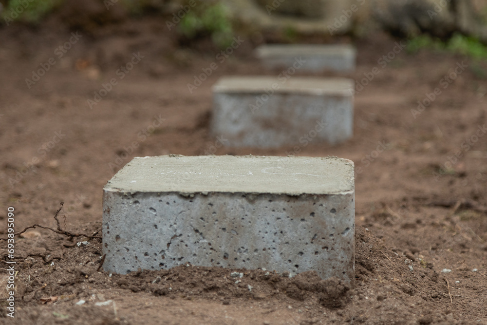 Une série de plots en béton alignés sur un sol pour supporter la ...