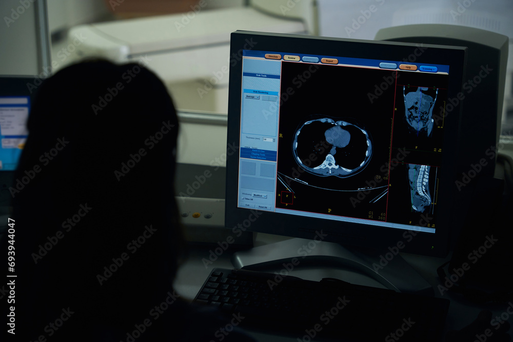 Radiographer performing computed tomography scanning from control room ...