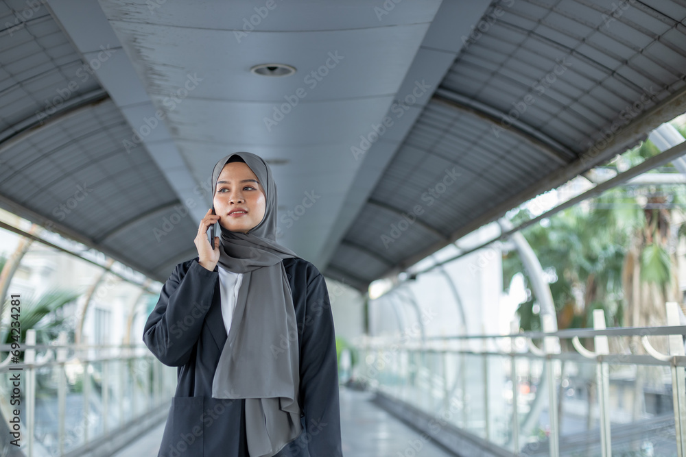 Asian beautiful muslim woman wear hijab talking with mobile phone ...
