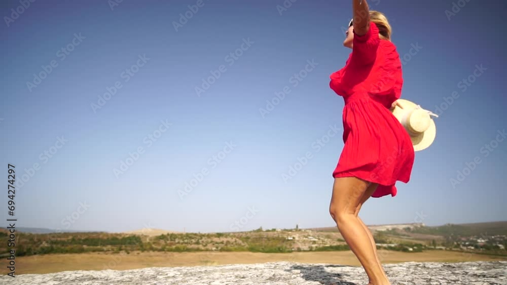 Vidéo Stock woman in a red dress and straw hat standing on a rock ...