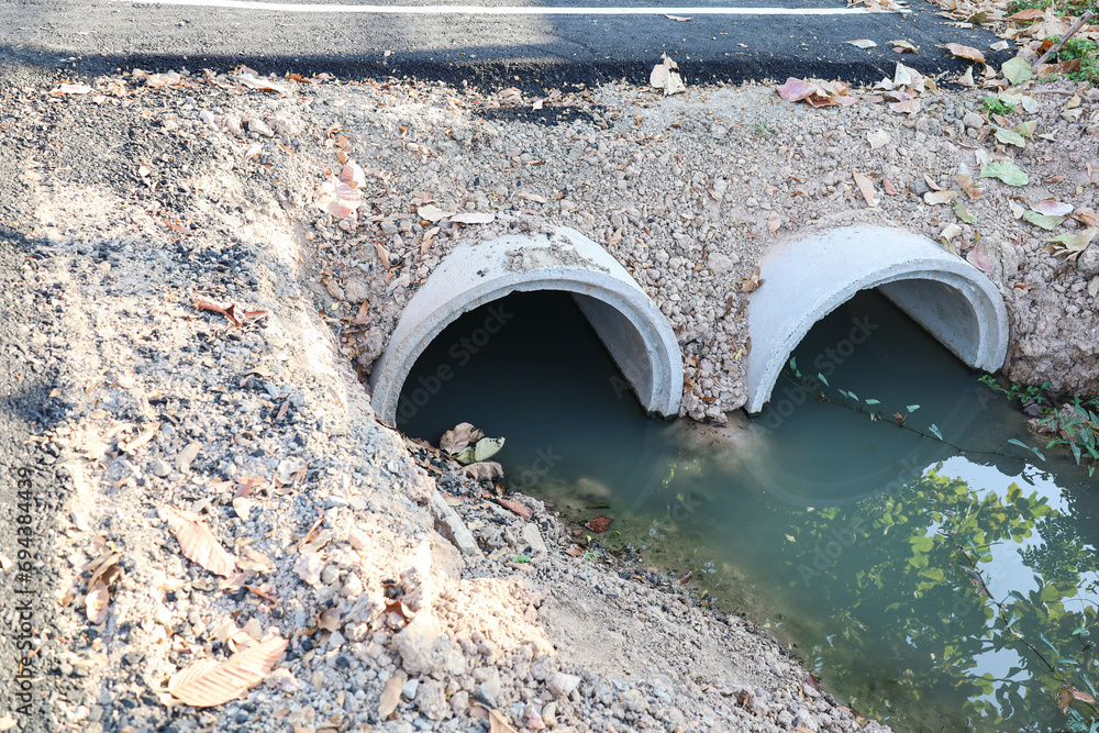 Two concrete drainage pipes. Twin culverts contain water in both wells ...
