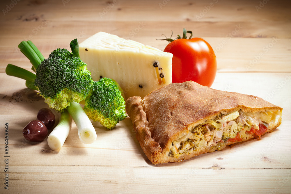 Slice of Sicilian scacciata with broccoli, fresh onion, olives, and ...