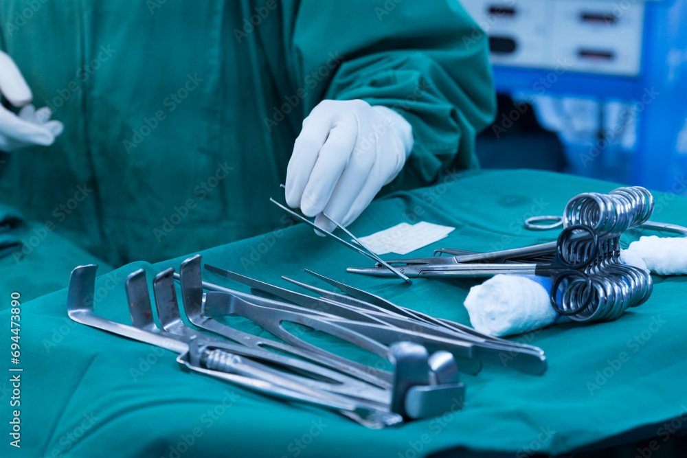 Surgeon doctor's hand with hygiene glove taking surgical clamps and ...