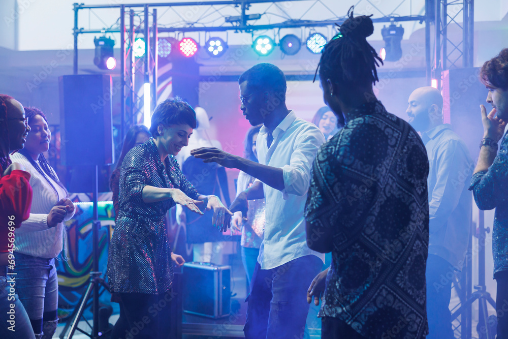 Cheerful dancers doing dance battle while having fun and partying with ...