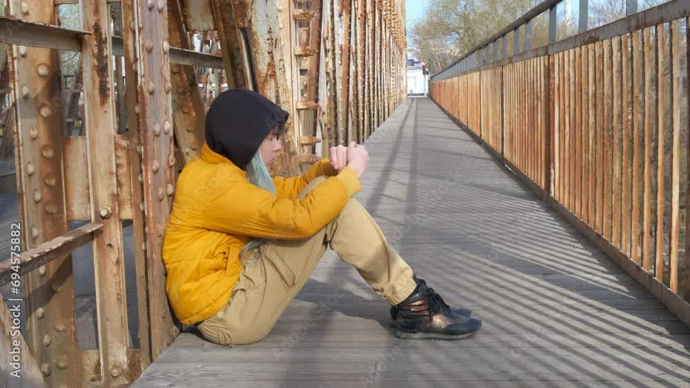 Hopeless teen on bridge. A hopeless teen girl with blue hairstyle ...