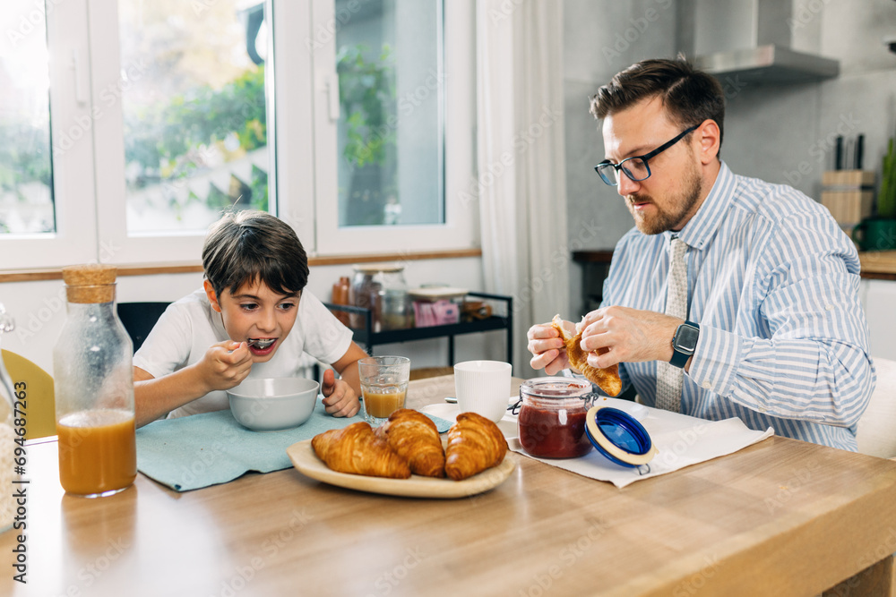 Boy is eating breakfast with his father before he goes to work. Stock ...