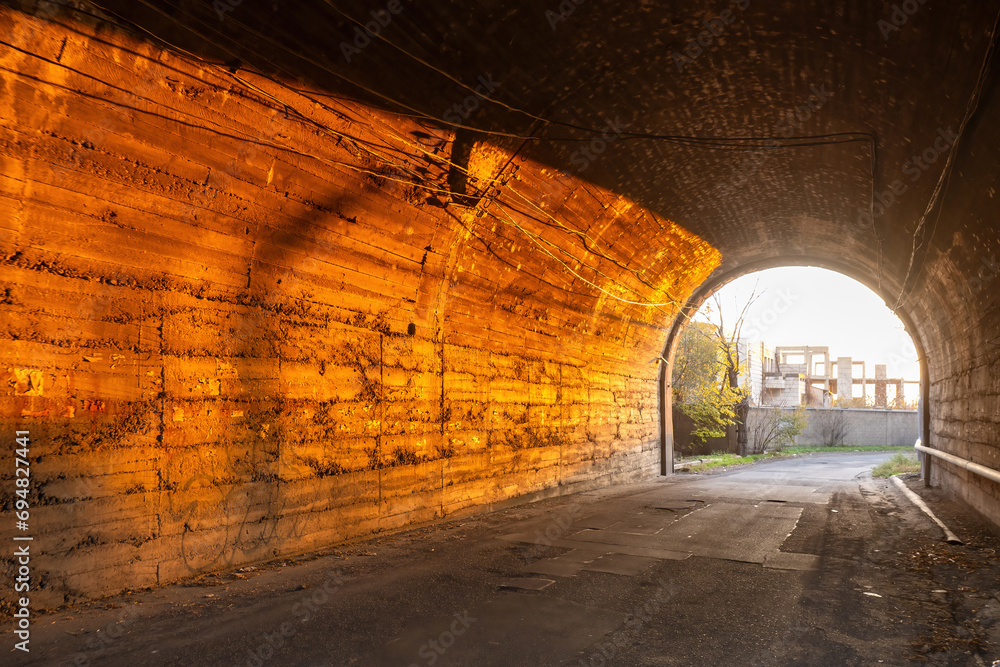 City tunnel with concrete walls. Street corridor with wires under ...