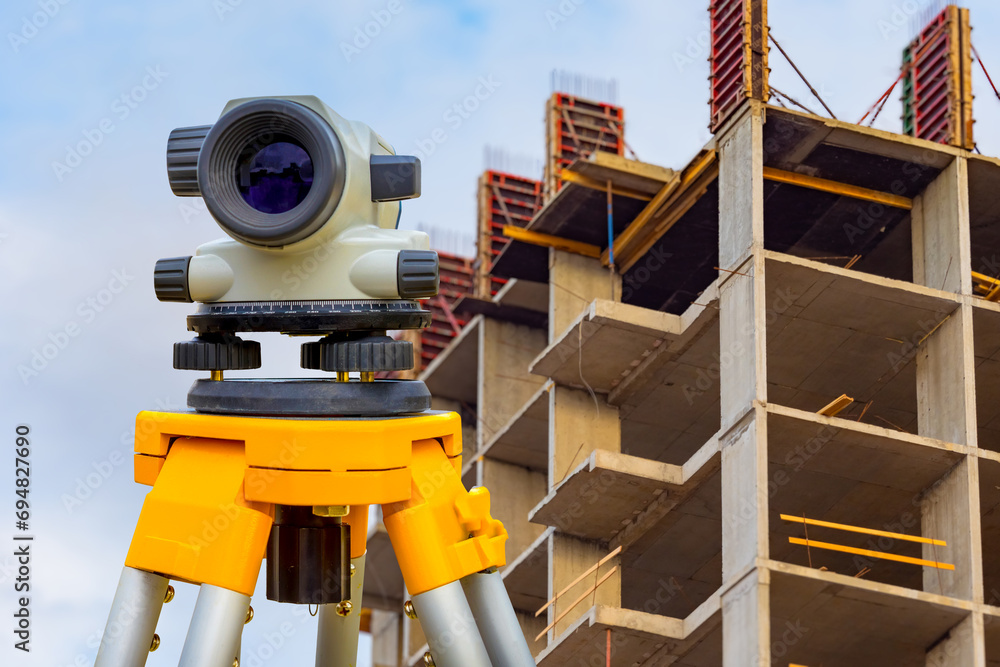 Geodetic equipment. Optical theodolite near house under construction ...
