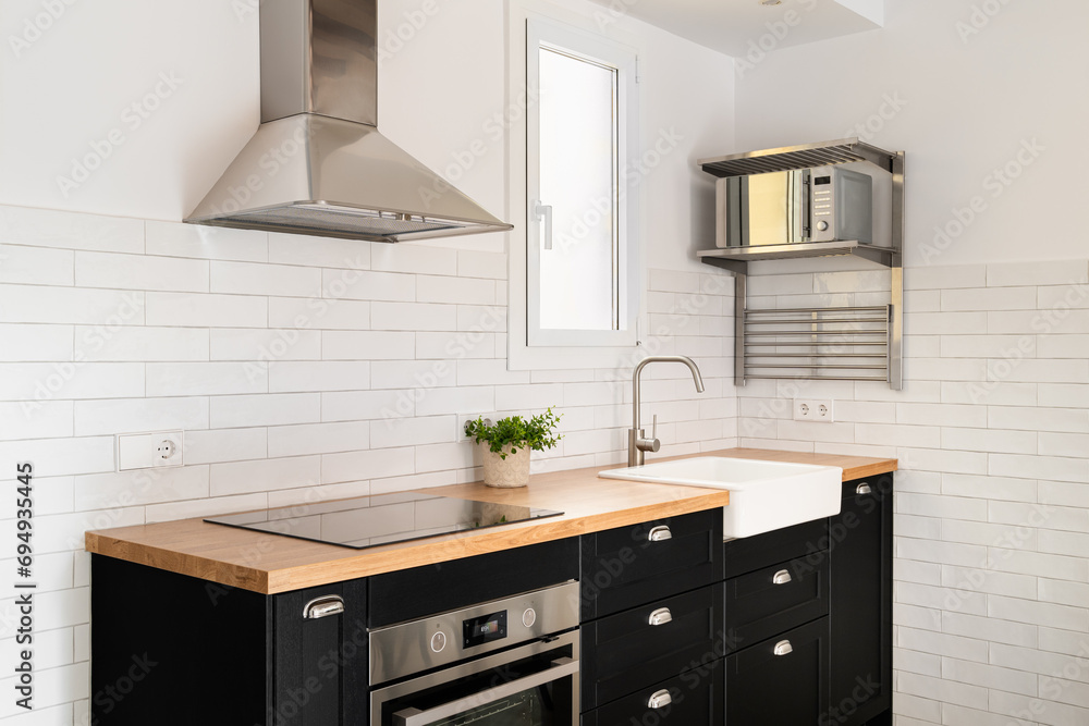 Kitchen island with convection hob and oven with black drawers and wood ...