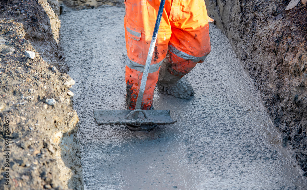 Concrete cast-in-place work. Builder leveling wet concrete. Concrete ...