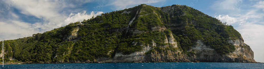 Weathered seaside rock face texture with parts of green and blue water ...