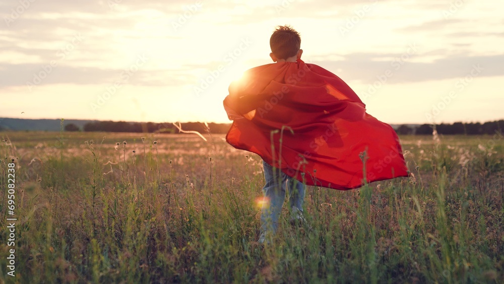 Fotografia do Stock: Boy races along field with raincoat billowing in ...