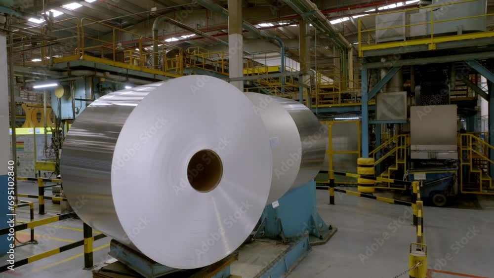 The moment when aluminum is prepared for cutting to form cans in a ...