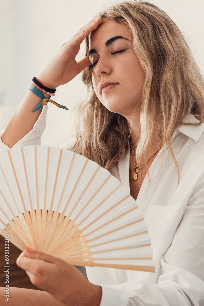 Overheated female sitting on couch in living room at hot summer weather ...