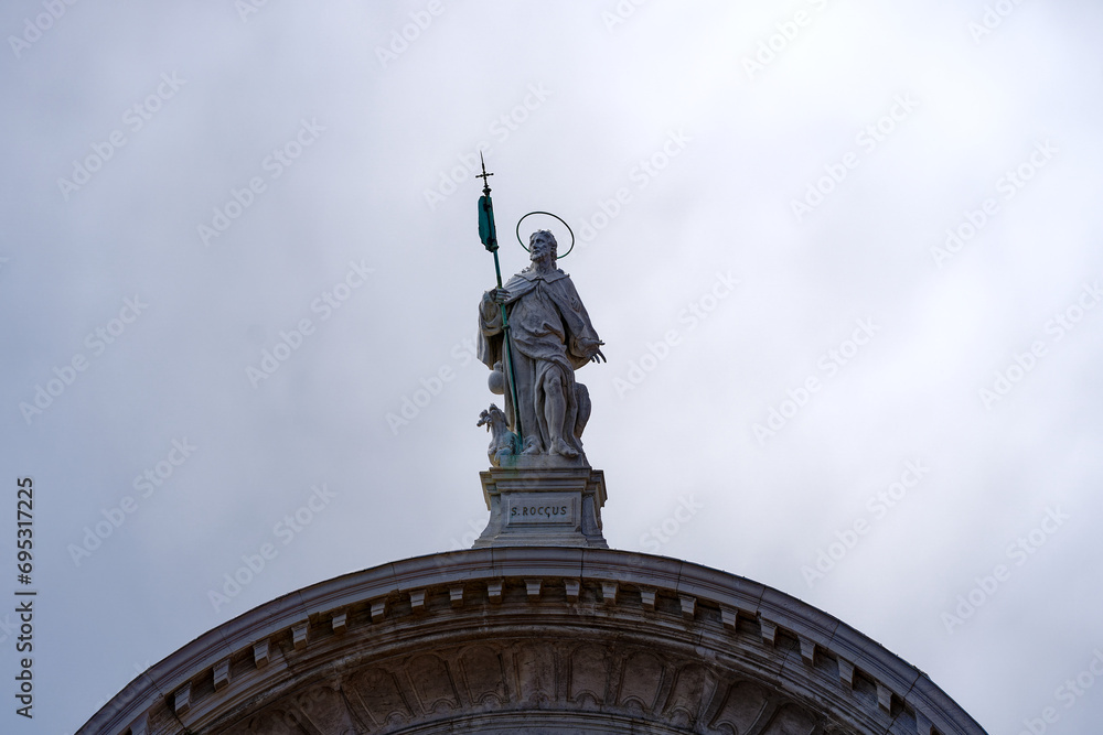White stone facade of church San Rocco with sculpture of saint San ...
