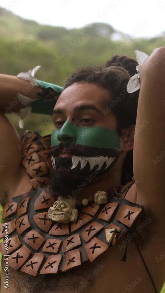 Man in body paint and traditional clothes with dreadlocks performing a ...