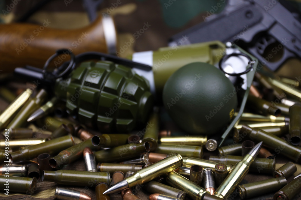 Different types of ammunition and grenades on a camouflage background ...