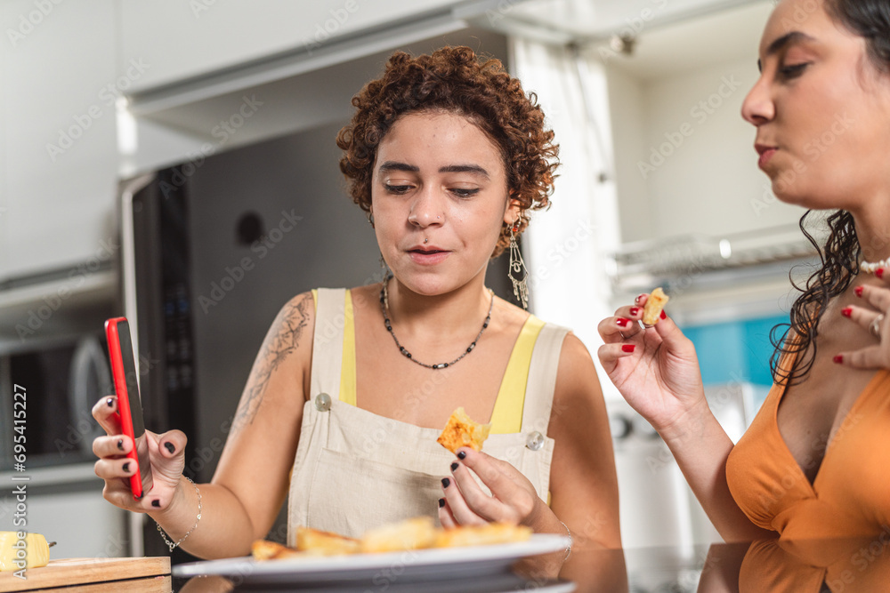 Young women in the kitchen eating tapioca dice, a traditional snack ...