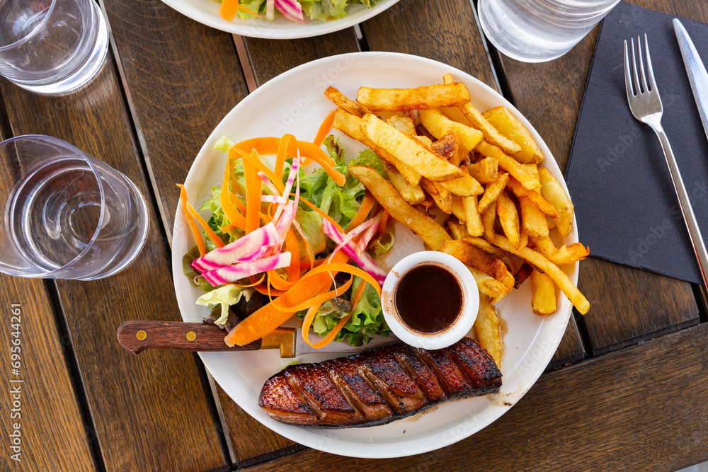 Juicy roasted duck magret served sauce framboise, french fries and ...