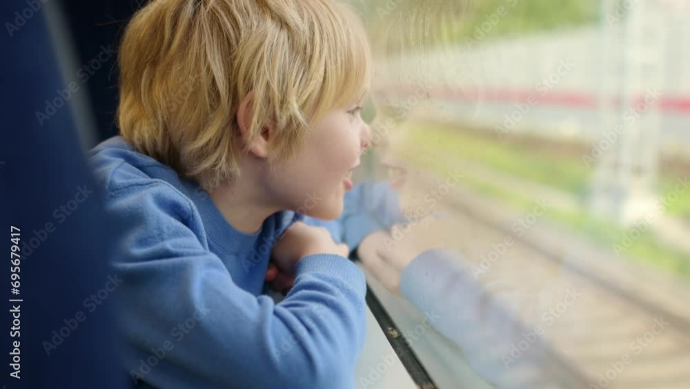 Cute teenage boy having fun during a ride in a subway train carriage or ...