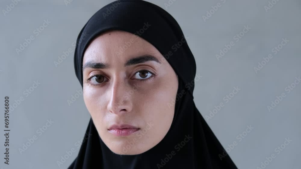 Muslim woman in black hijab looks sadly at camera. Close-up: sad face ...
